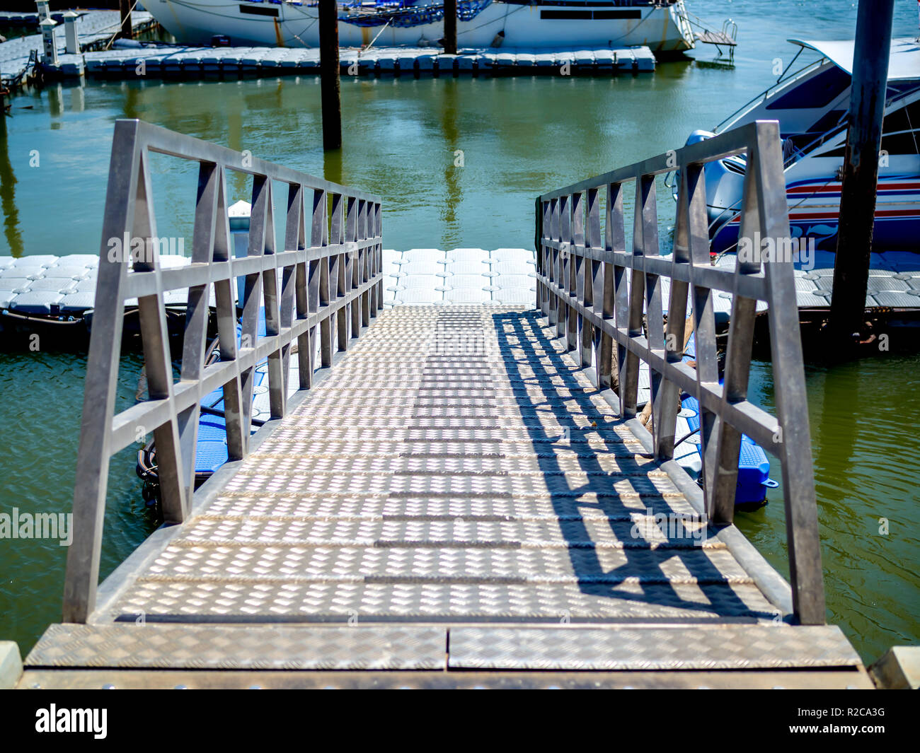 Metal walkway ladder docked to the floating plastic walkway in the port ...