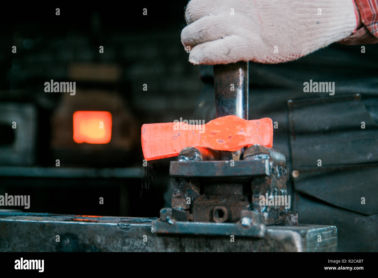 Blacksmith working a glowing iron in an old forge hi-res stock ...