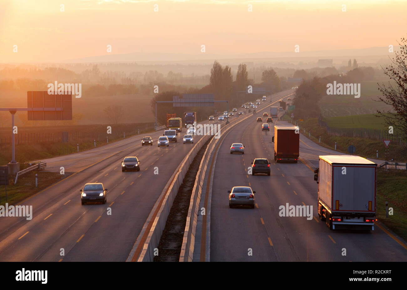 Cars on highway road at sunset Stock Photo - Alamy