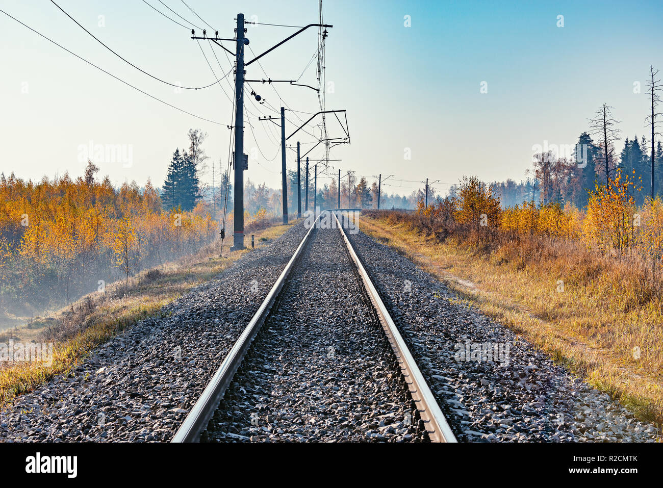 Electric railway line at autumn early morning time Stock Photo - Alamy