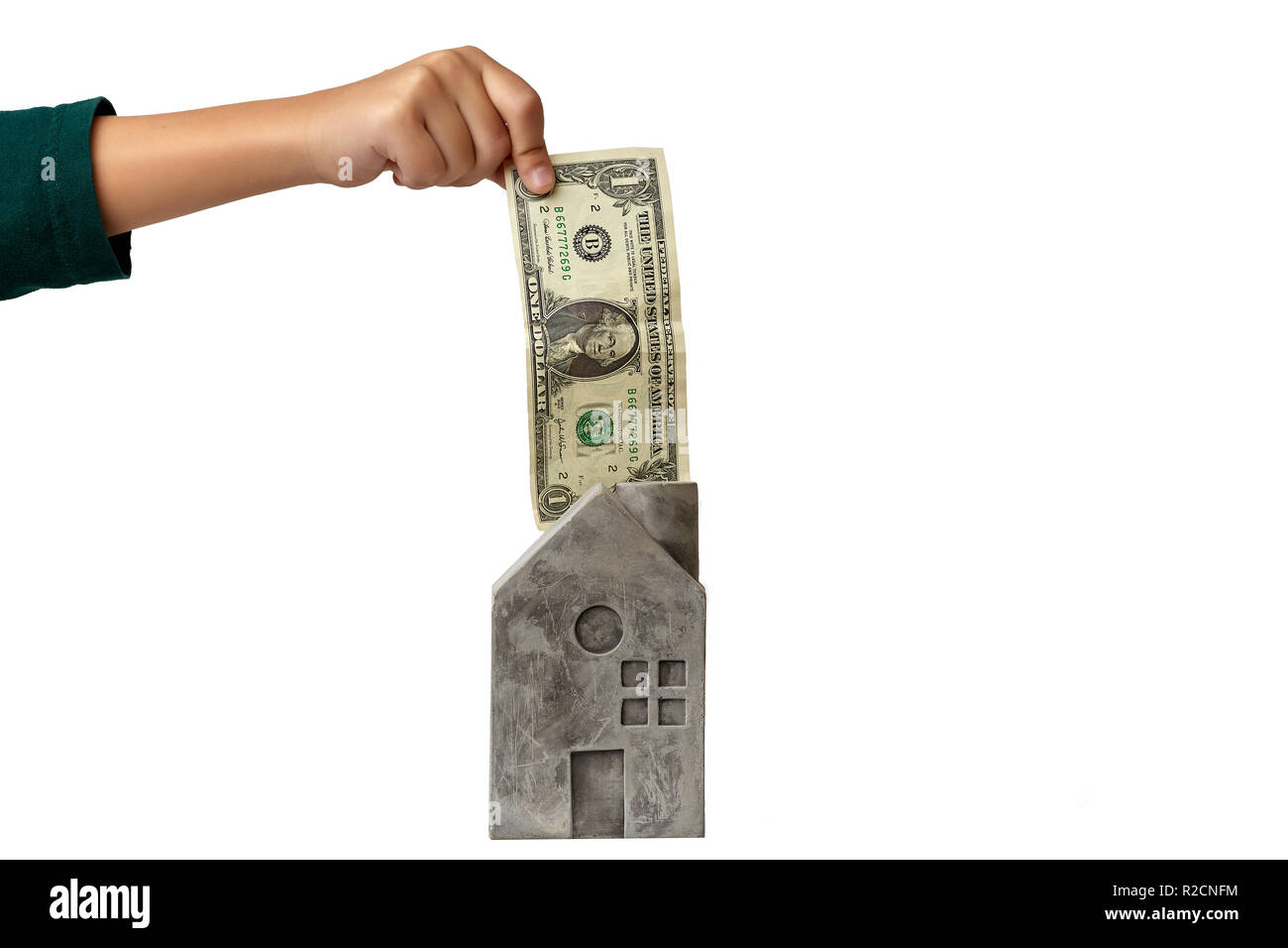 Hand of anonymous kid holding dollar banknote over stone toy houses on ...