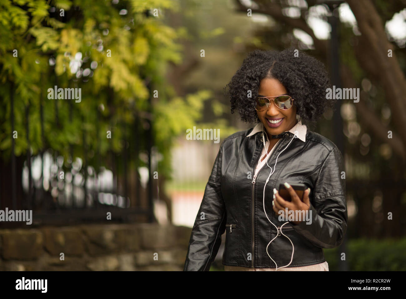 Confident African American Woman walking and texting Stock Photo - Alamy
