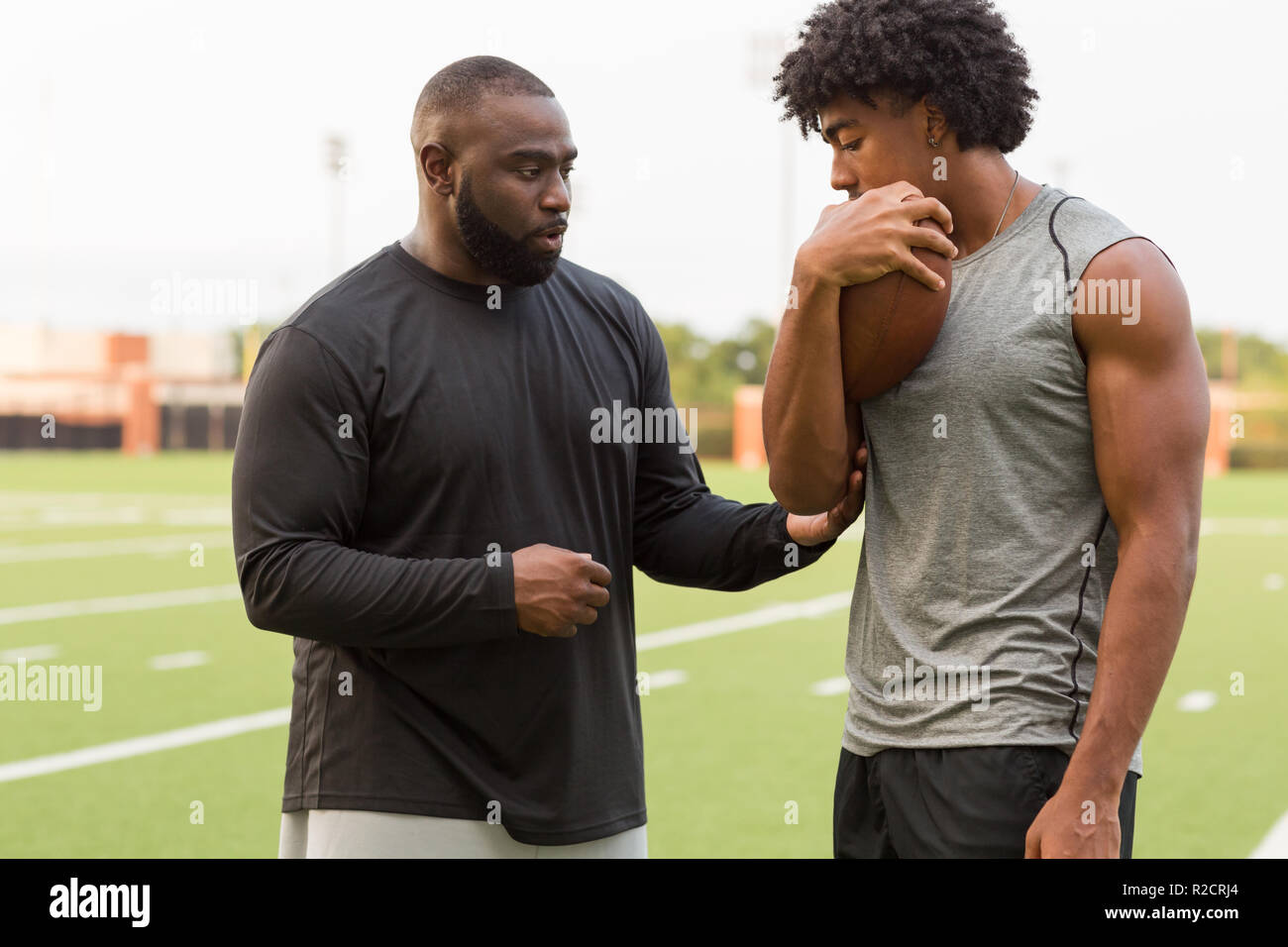 American Football coach training a young athlete Stock Photo - Alamy