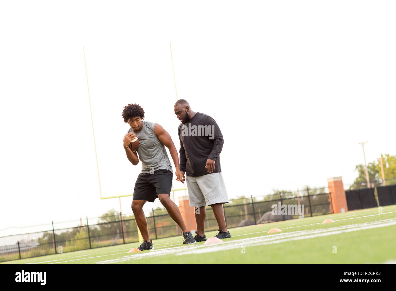 American Football coach training a young athlete Stock Photo - Alamy