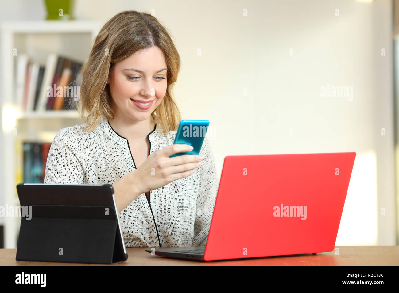Happy lady using multiple colorful devices on a desk at home Stock ...
