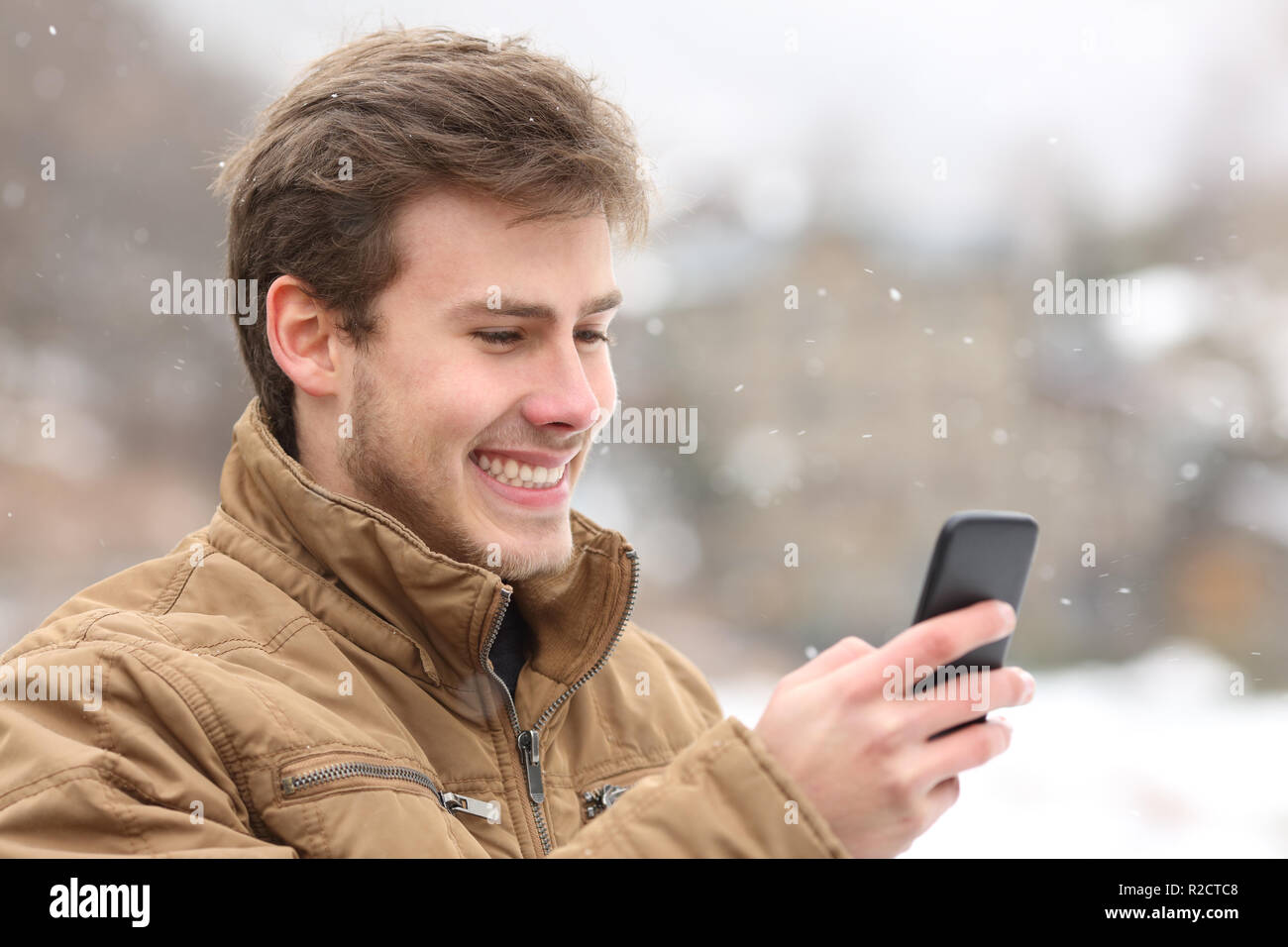 Happy man checking smart phone content on winter holiday Stock Photo ...