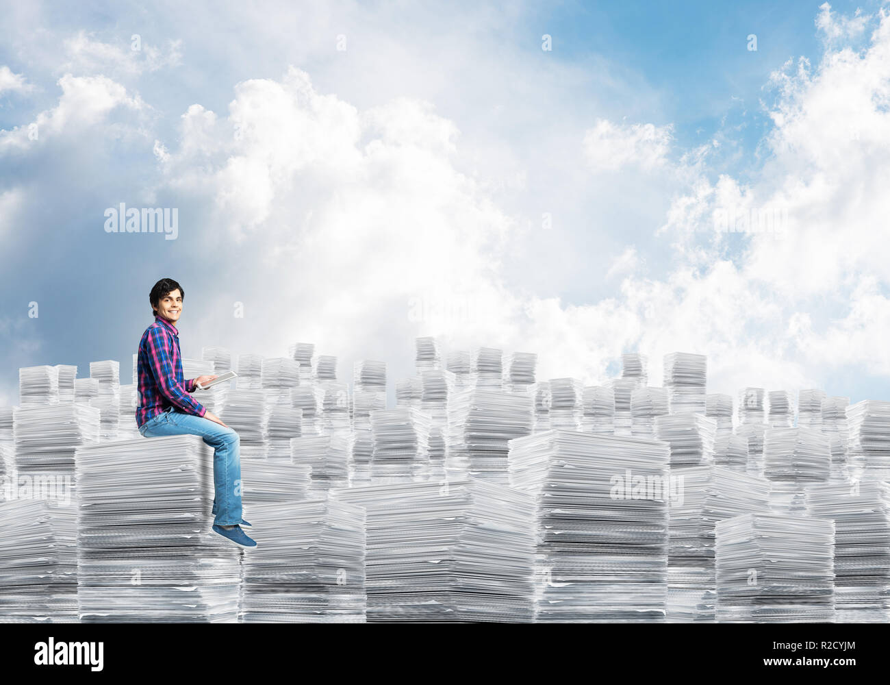 Attractive man sitting on pile of paper documents Stock Photo - Alamy