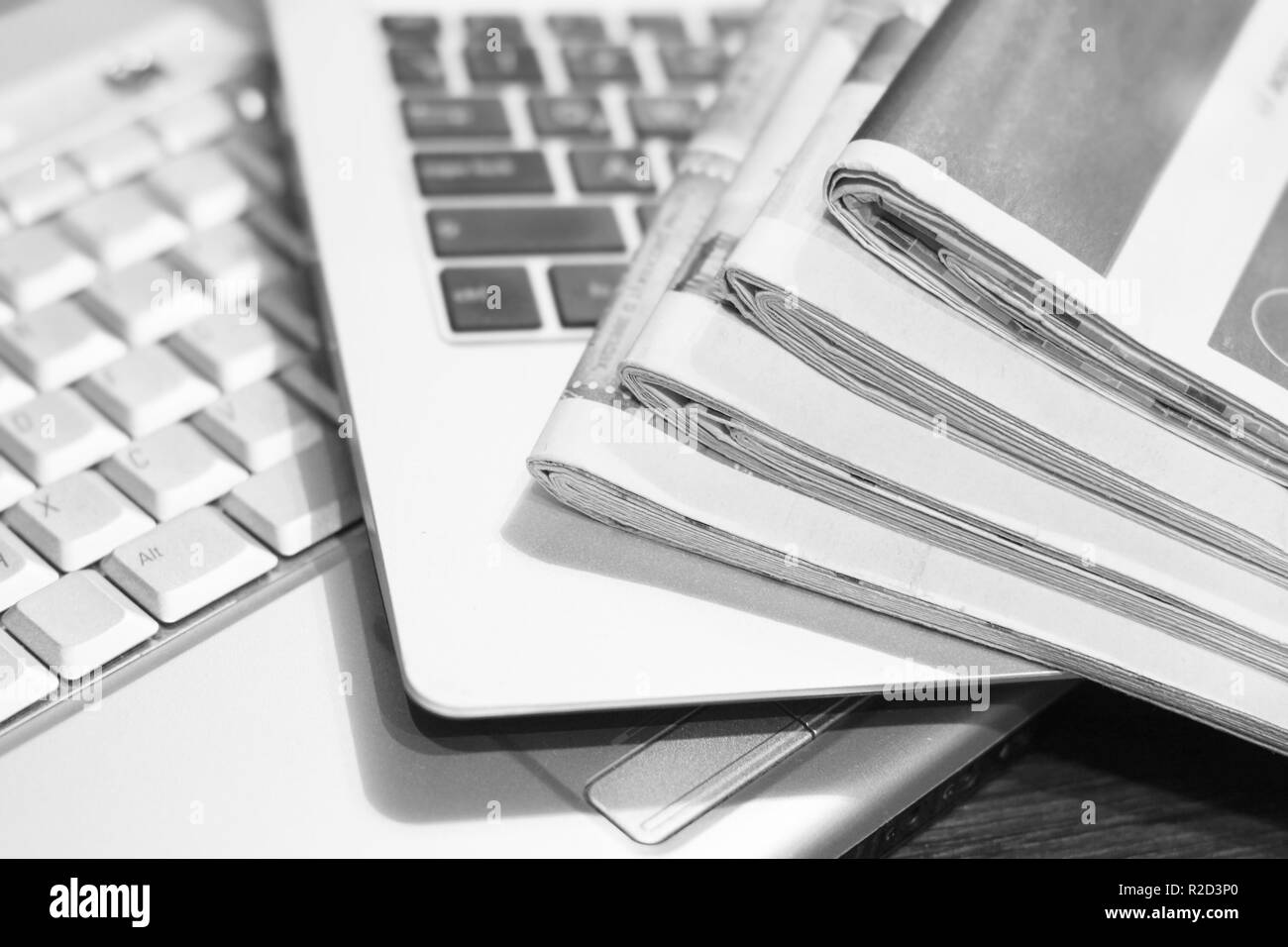 Business concept. Stack of newspapers and two computers. Lots of ...