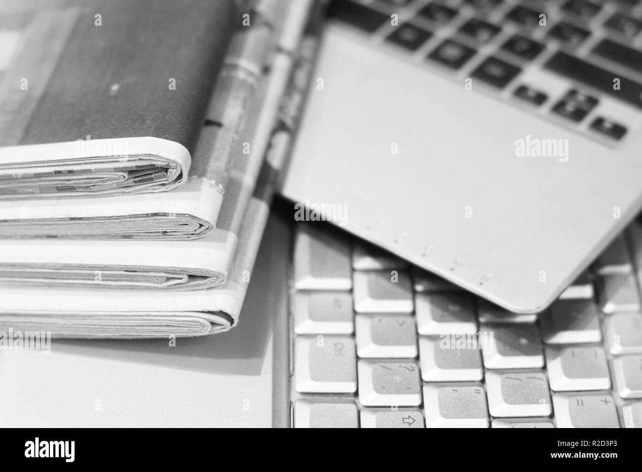 Business concept. Stack of newspapers and two computers. Lots of ...