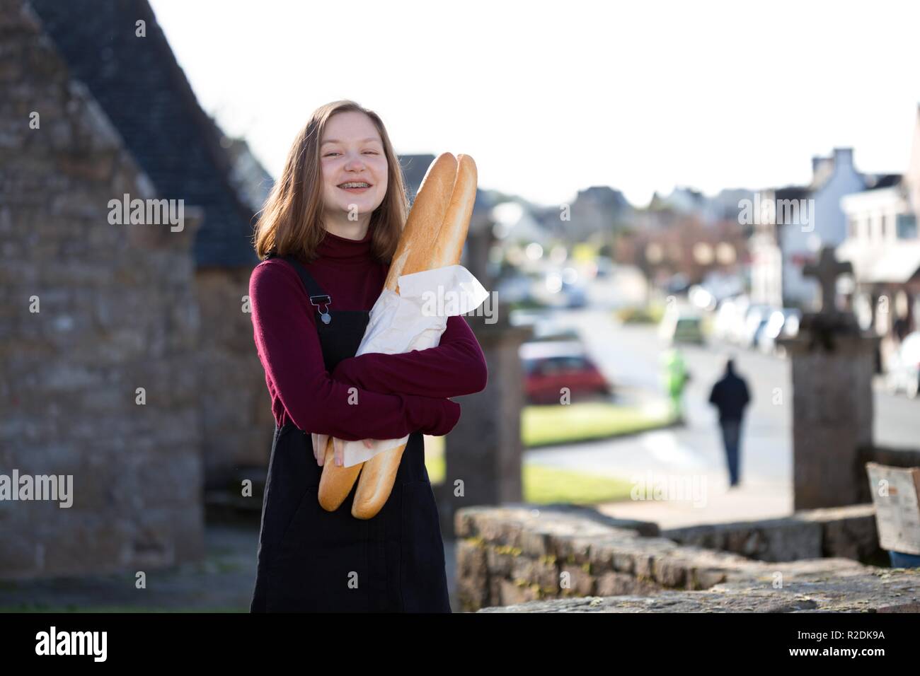 French girl with baguettes on the street side of the city Stock Photo ...