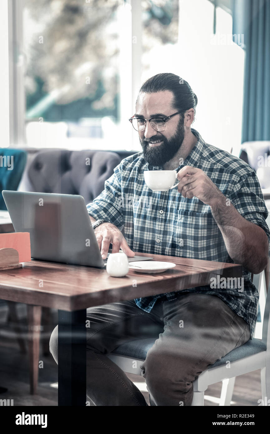 Bearded freelancer writer working on his laptop having coffee Stock ...