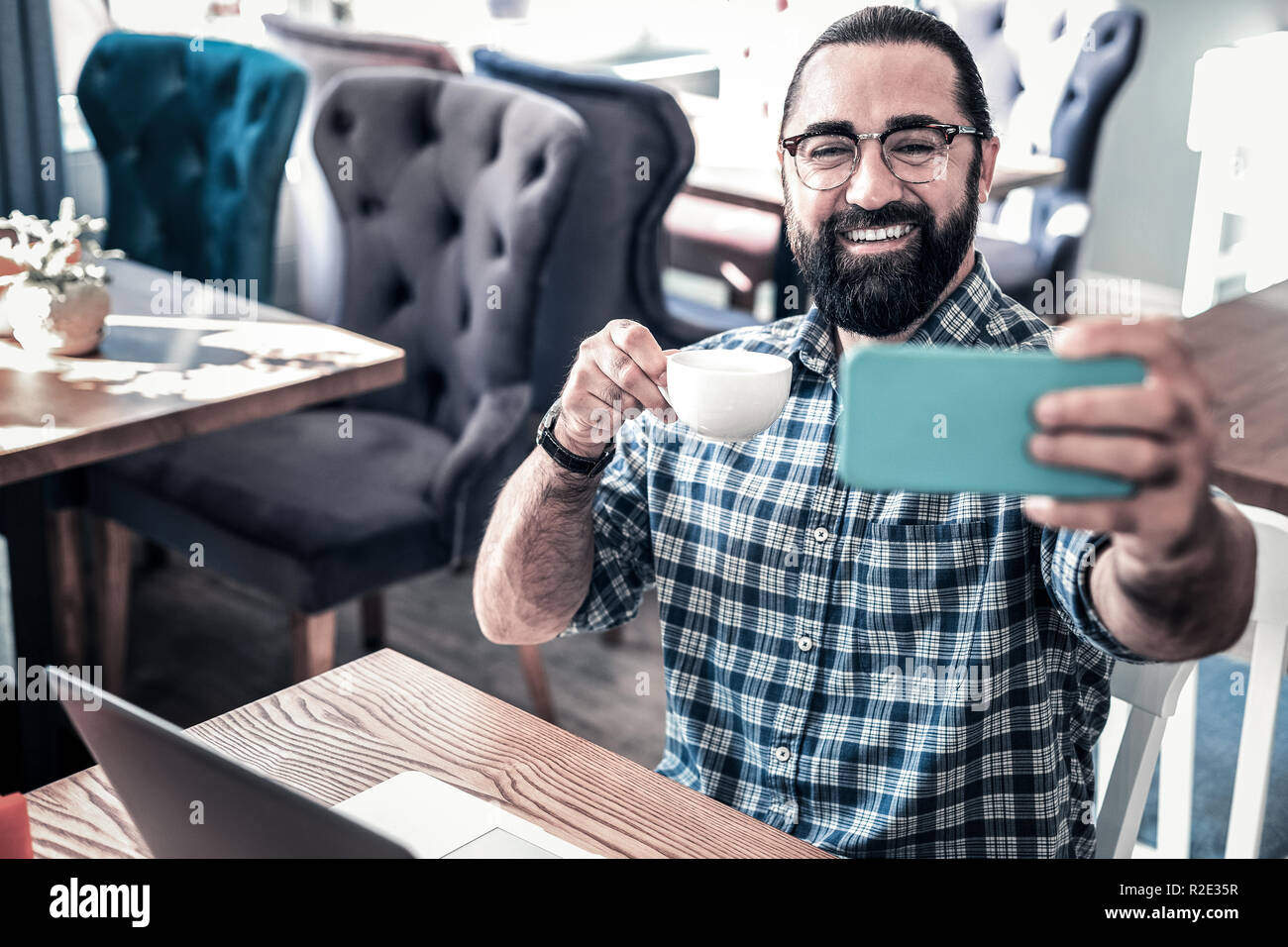 Coffee for customer. Dark-eyed beaming beautiful barista smiling while ...