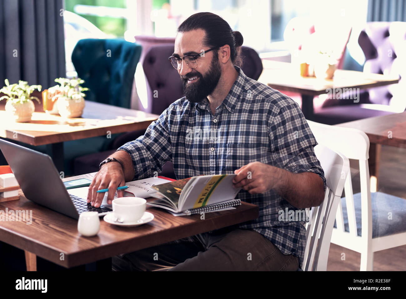 Professional Chinese tutor preparing for the class sitting in cafeteria ...