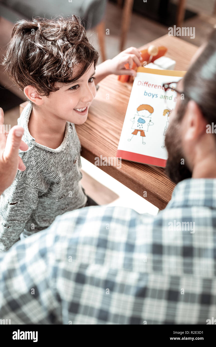 Handsome boy listening to his private tutor teaching him reading Stock ...