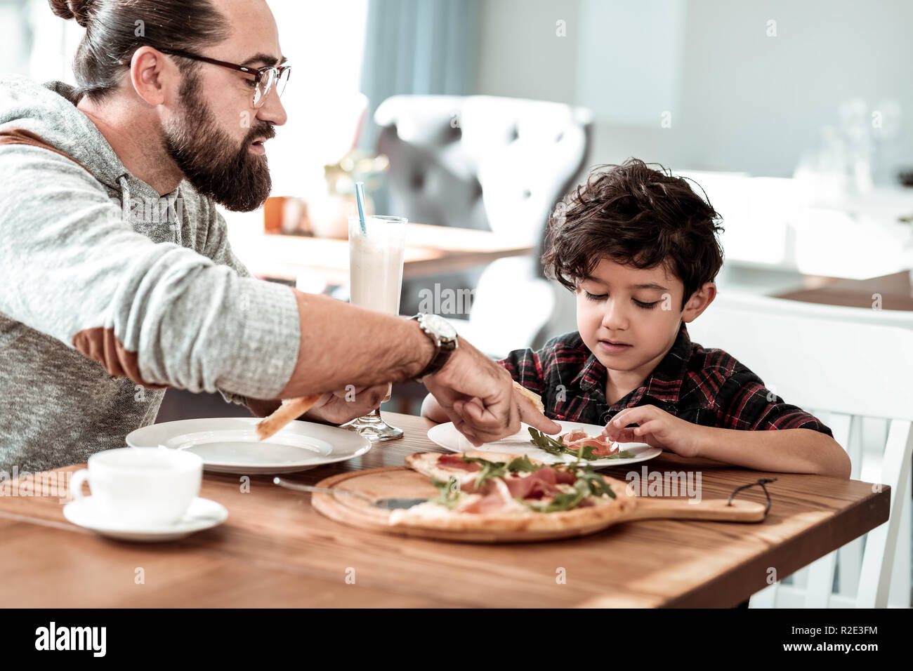 Father and son celebrating fathers day together eating pizza in ...