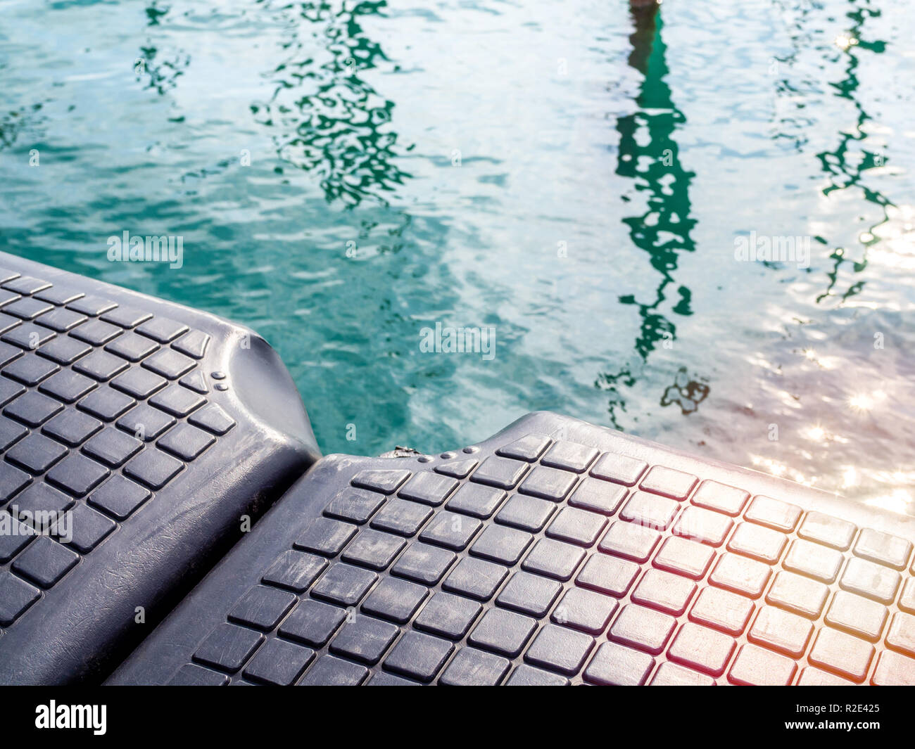 Black plastic pontoon walk way floating in the sea with copy space ...