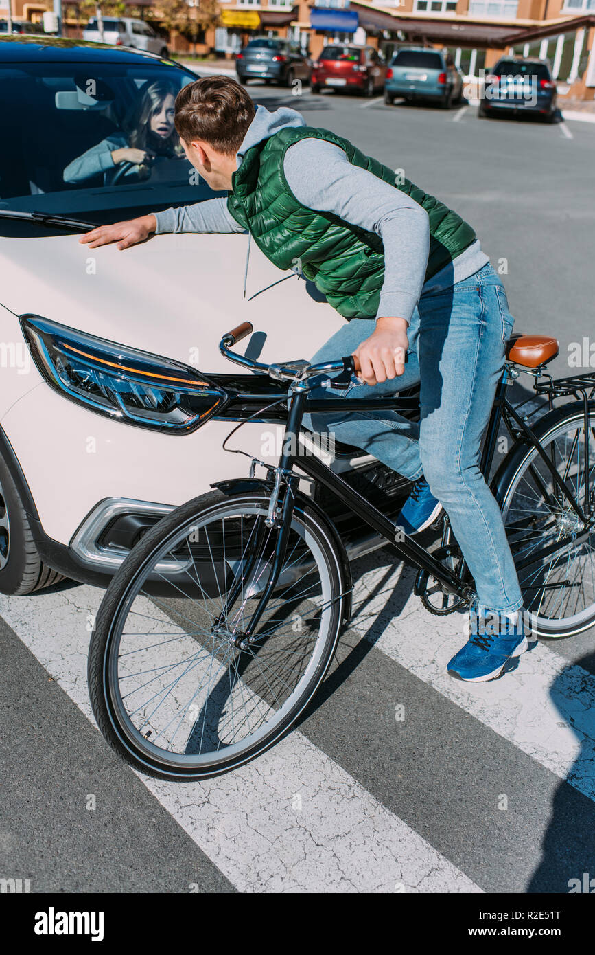 male bicycle rider hit by woman in car on road, car accident concept ...