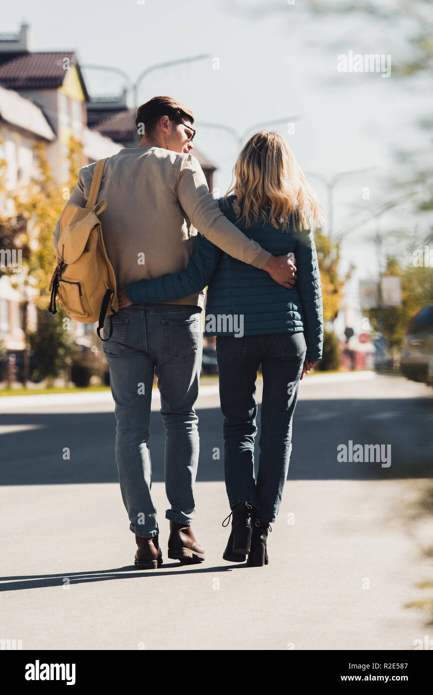back view of couple hugging while walking on street in new city Stock ...