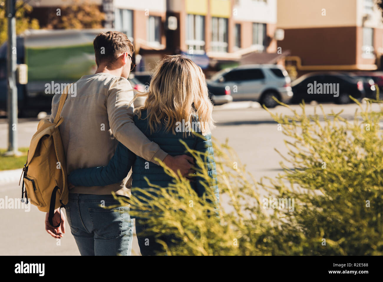 back view of couple hugging while walking on street in new city Stock ...