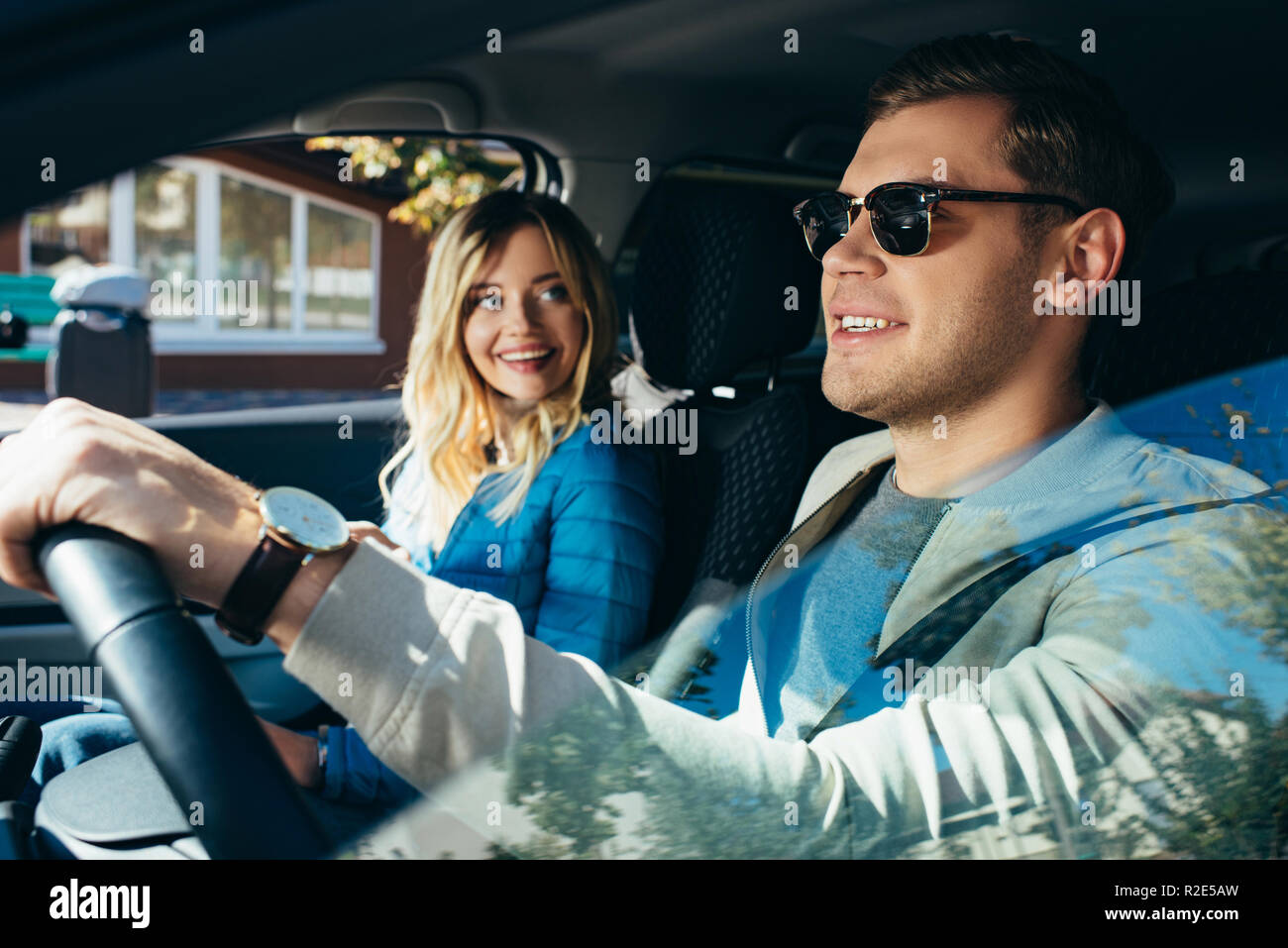 smiling woman at boyfriend driving car during vacation Stock Photo - Alamy