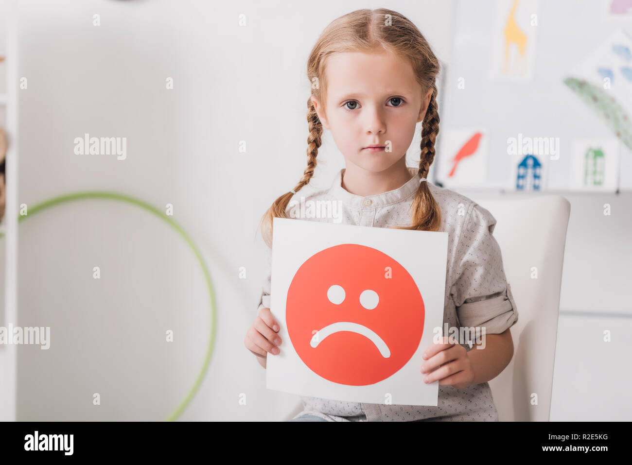 close-up portrait of lonely little child holding sad face symbol Stock ...