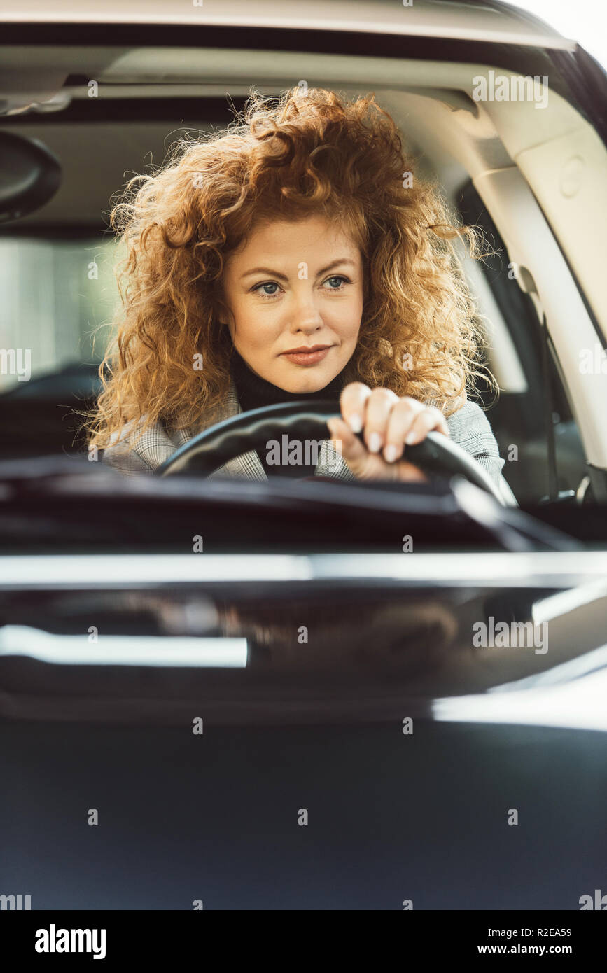 portrait of beautiful cheerful ginger curly woman driving car Stock ...