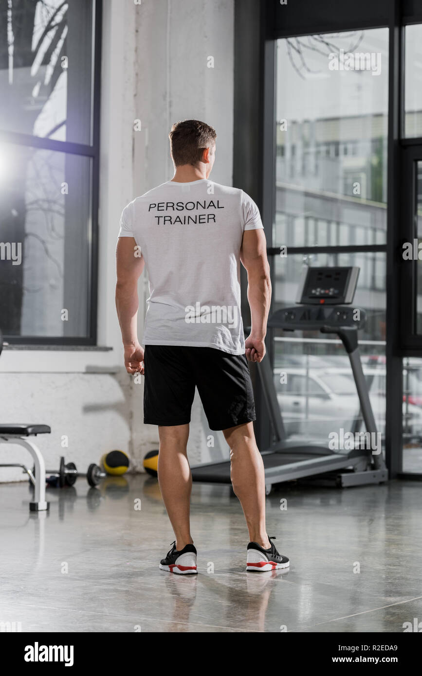 back view of athletic bodybuilder in shirt with text personal trainer ...