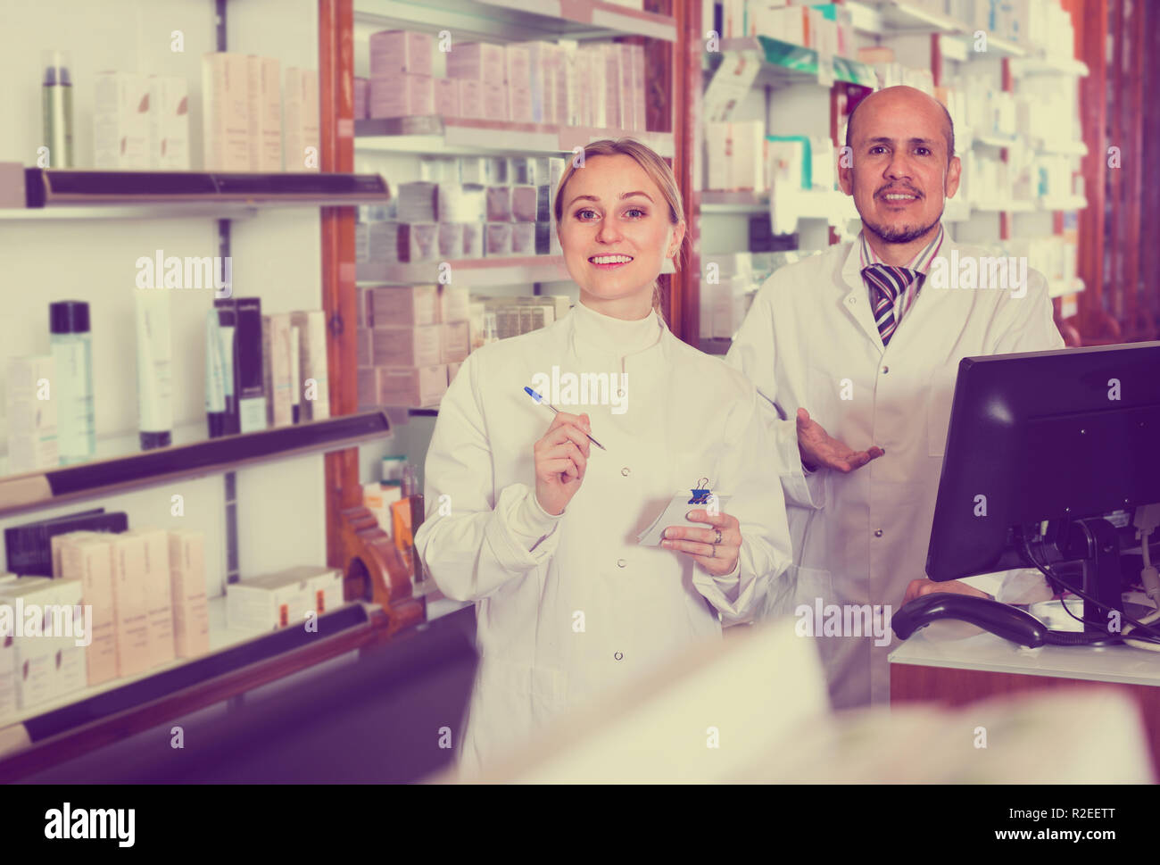 couple of pharmacists standing with a cash desk in the pharmacy Stock ...