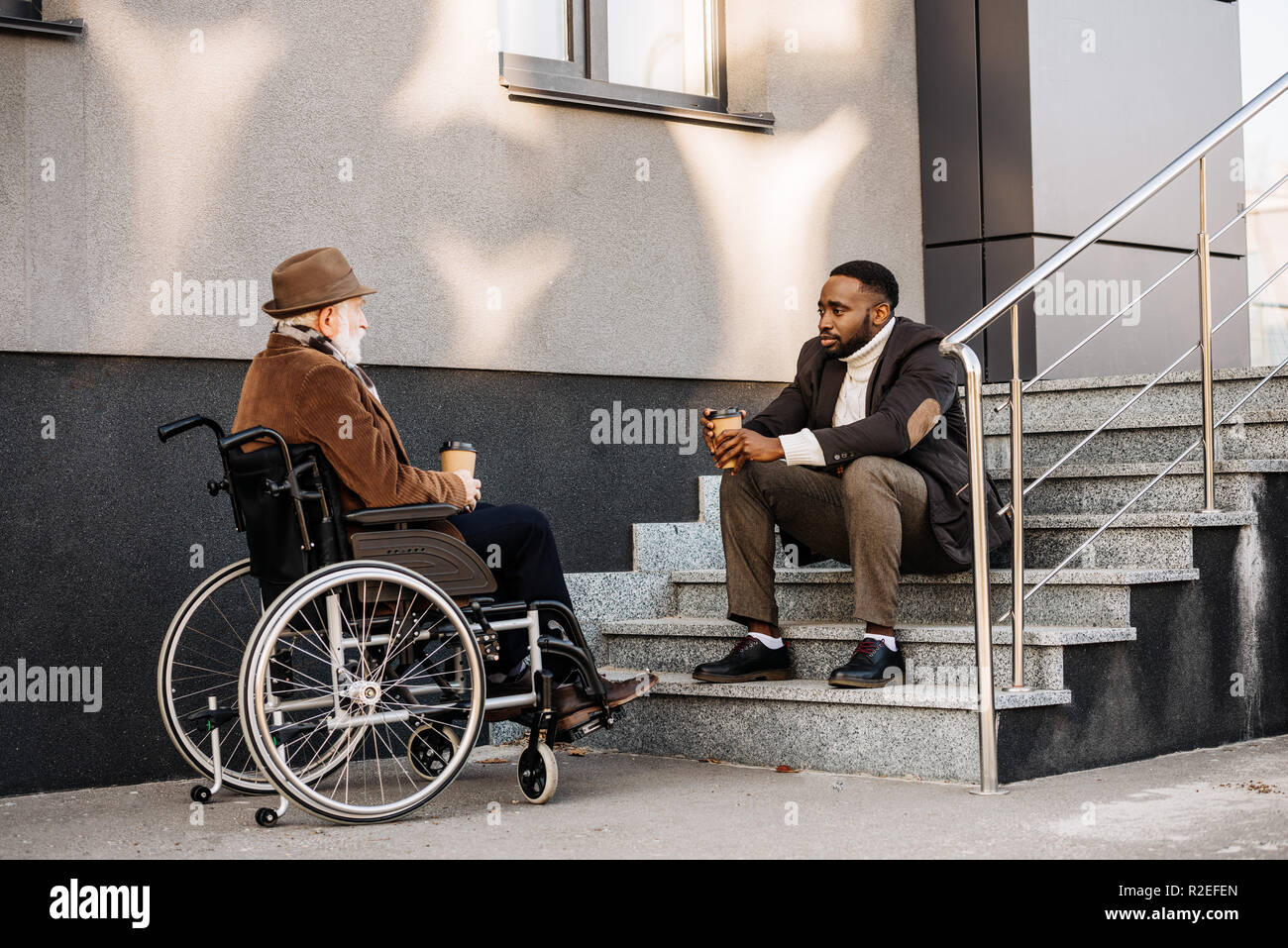 Senior Disabled Man In Wheelchair And African American Cuidador