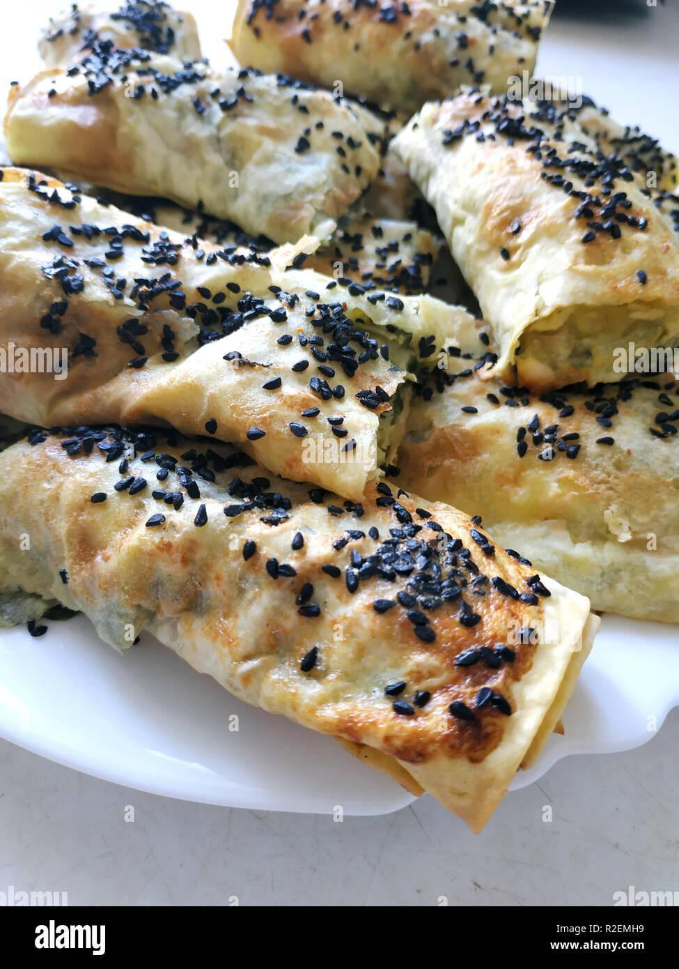 Cutted lavash pieces with vegetables. Burek with spinach and cheese and ...