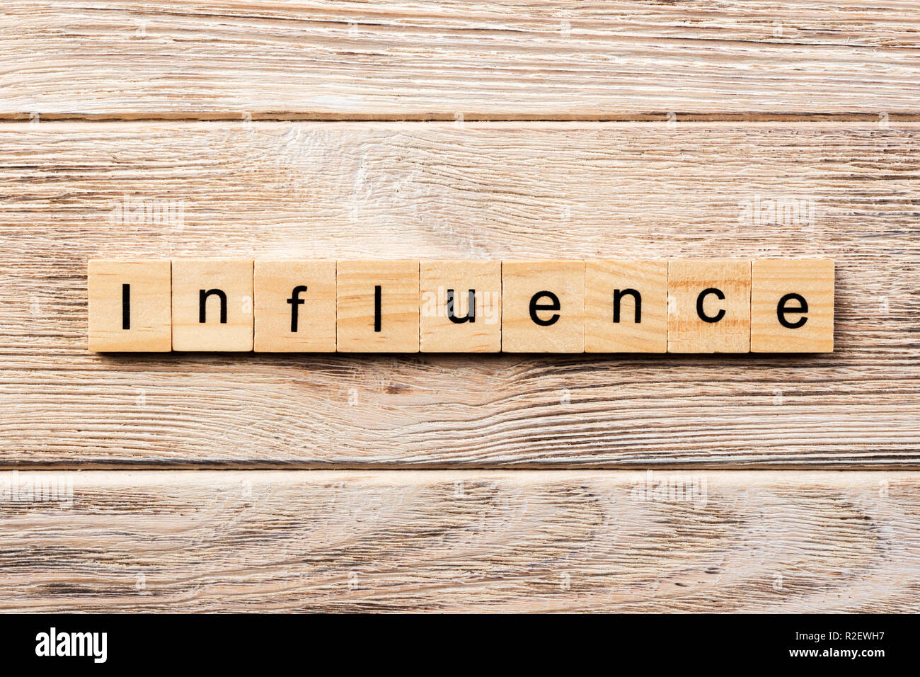 influence word written on wood block. influence text on table, concept ...