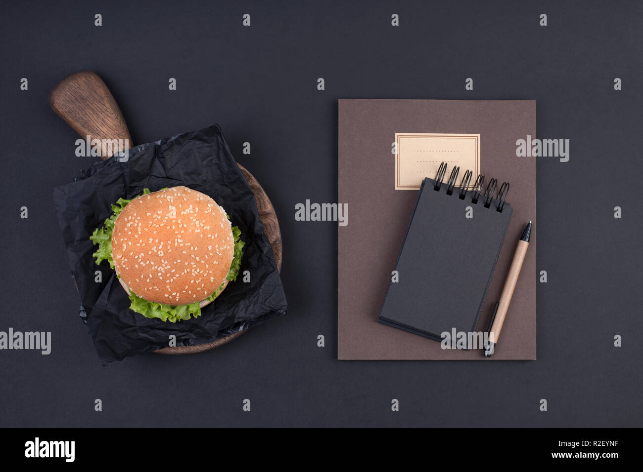 Big hamburger with sesame seeds on a black background. Fast food and ...