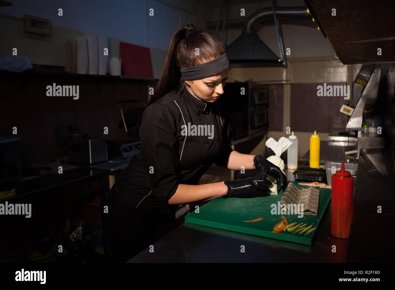 beautiful woman chef prepares sushi on restaurant kitchen Stock Photo ...