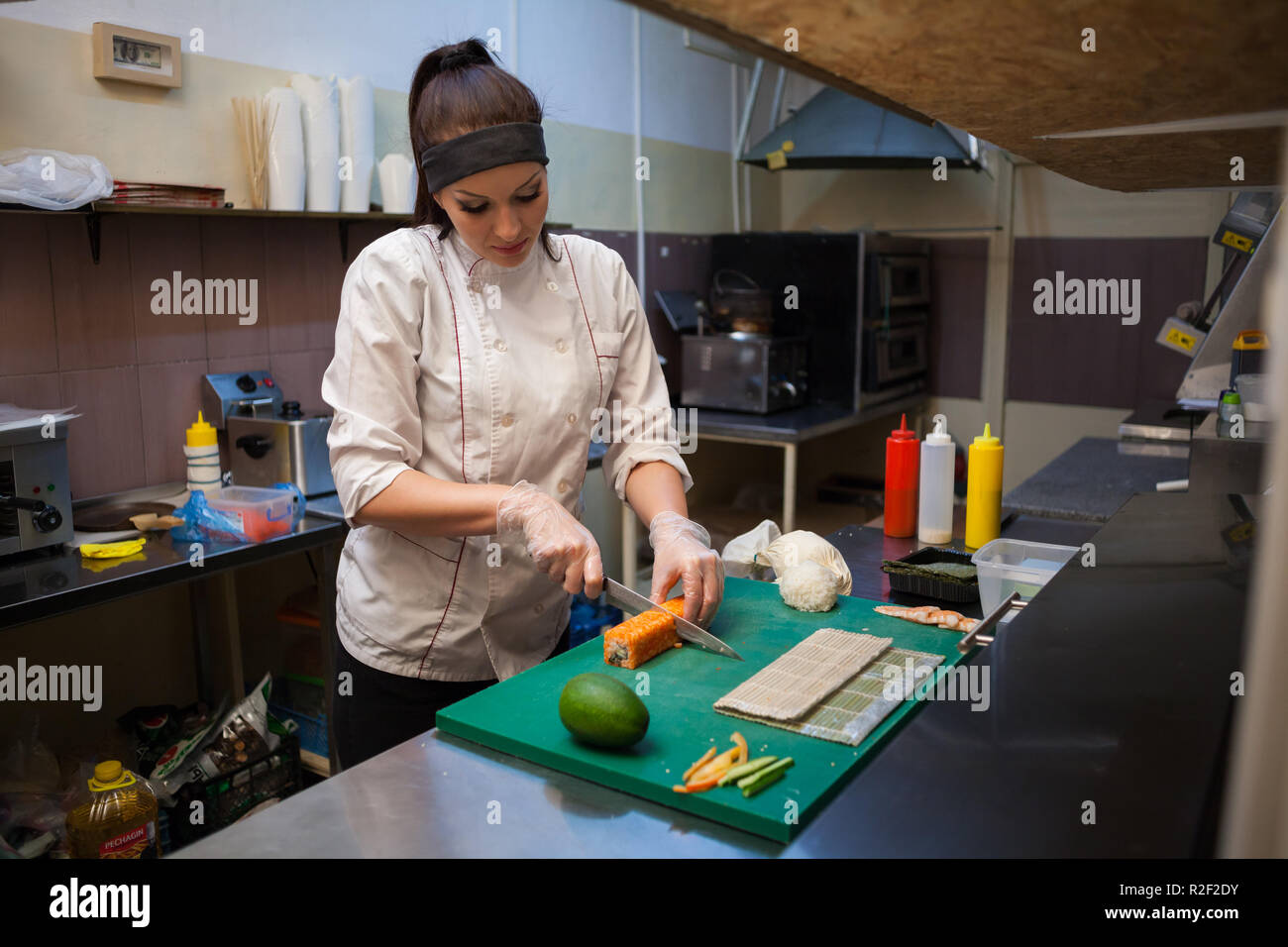 beautiful woman chef prepares sushi on restaurant kitchen Stock Photo ...
