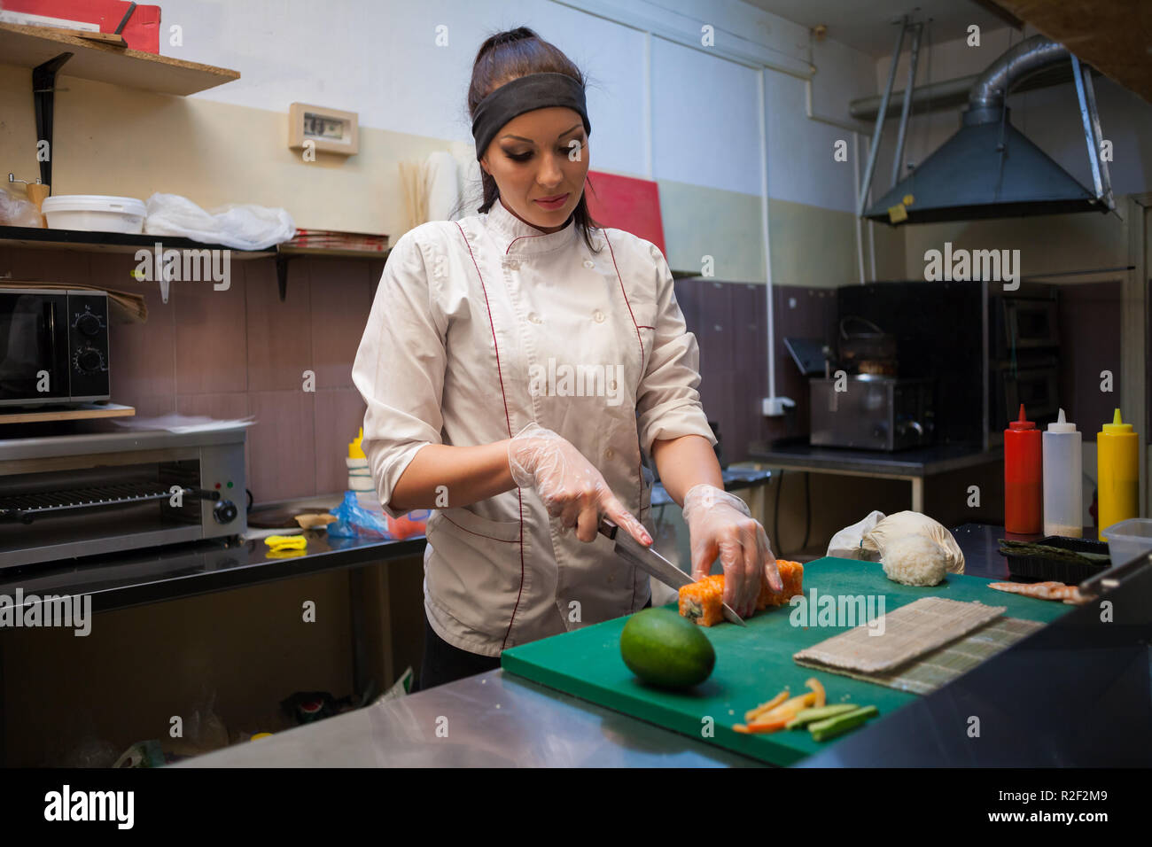 beautiful woman chef prepares sushi on restaurant kitchen Stock Photo ...