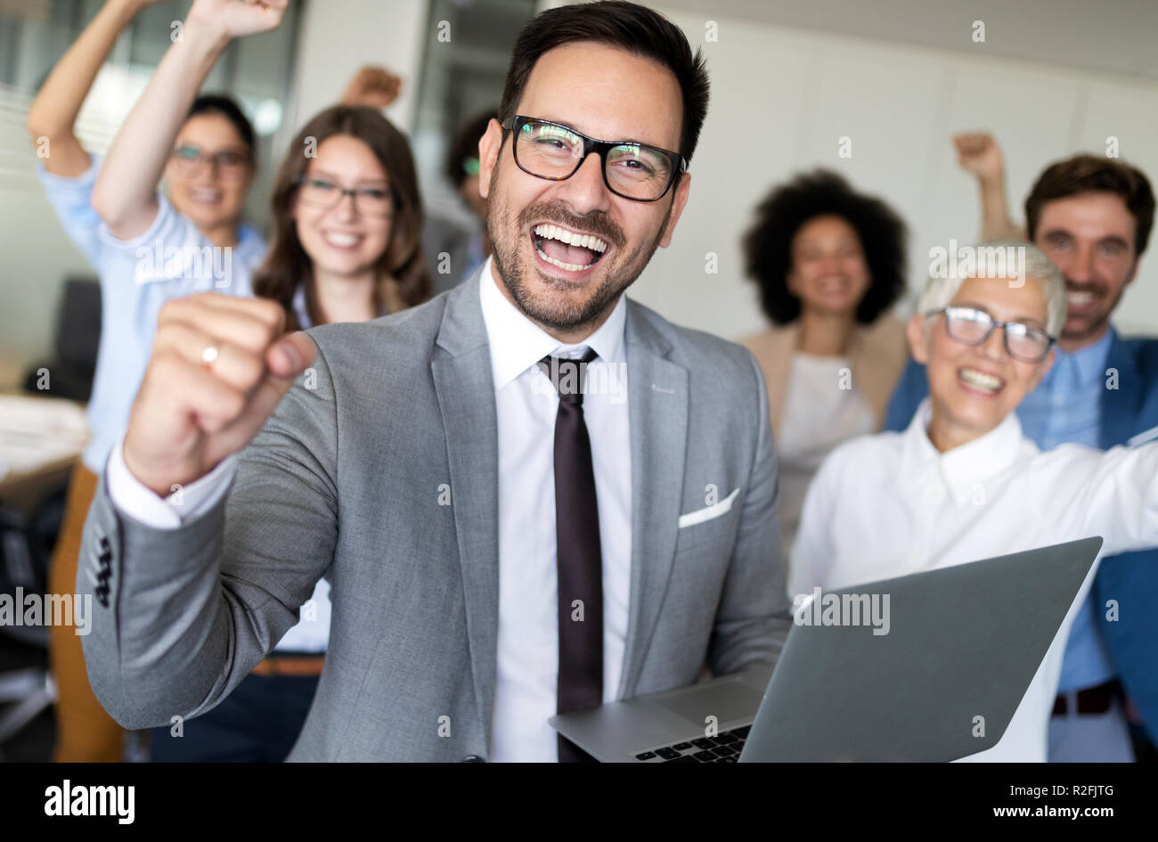 Happy business people celebrating success at company Stock Photo - Alamy