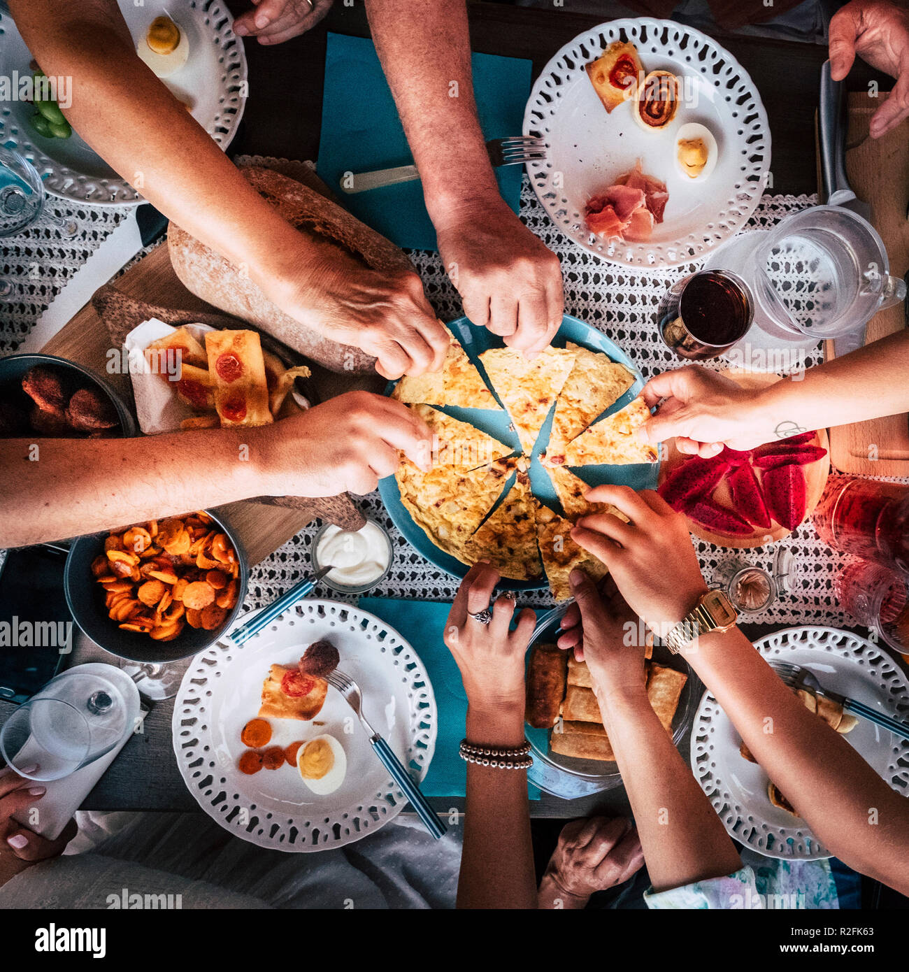 Aerial view from above for table and hands and a lot of food and drinks ...