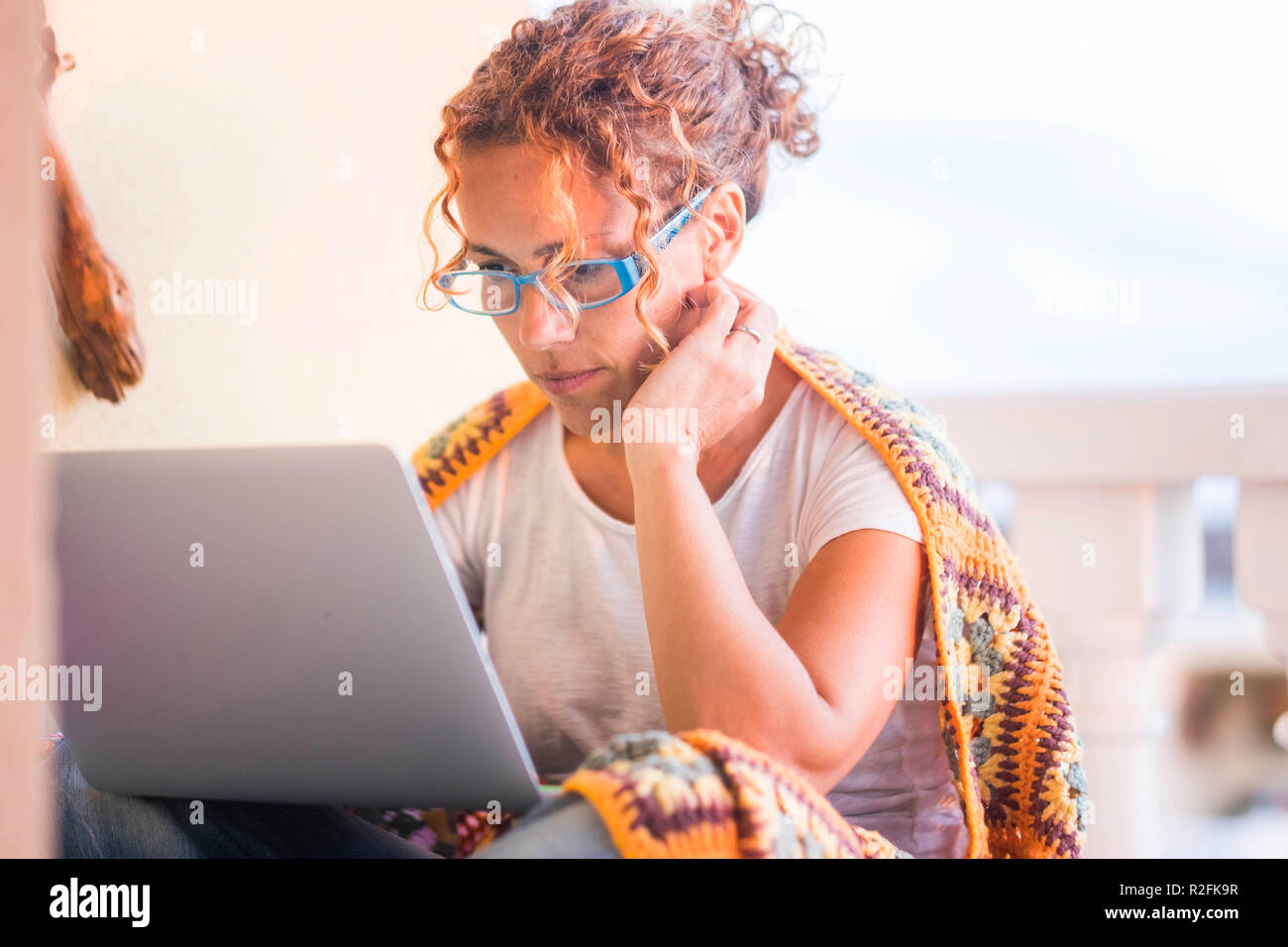 cute caucasian lady read on the laptop and work outdoor in the terrace ...