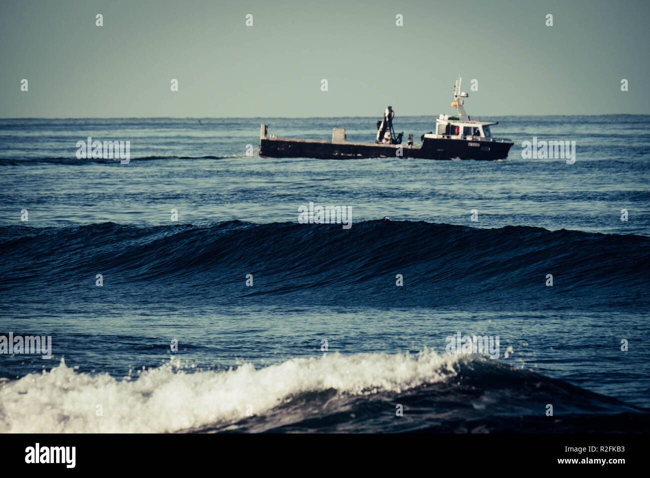 Boat in the waves in the ocean of Tenerife. Bad sea with big waves and ...