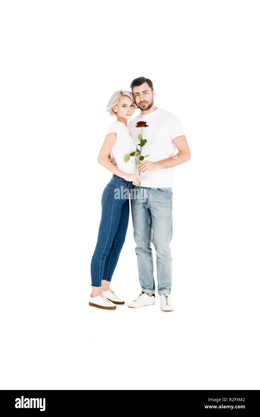 Attractive young adult couple with flower hugging while looking at ...