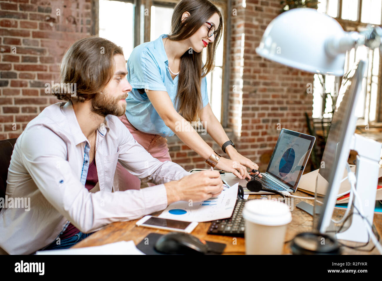 Young couple of colleagues dressed casually working together with ...