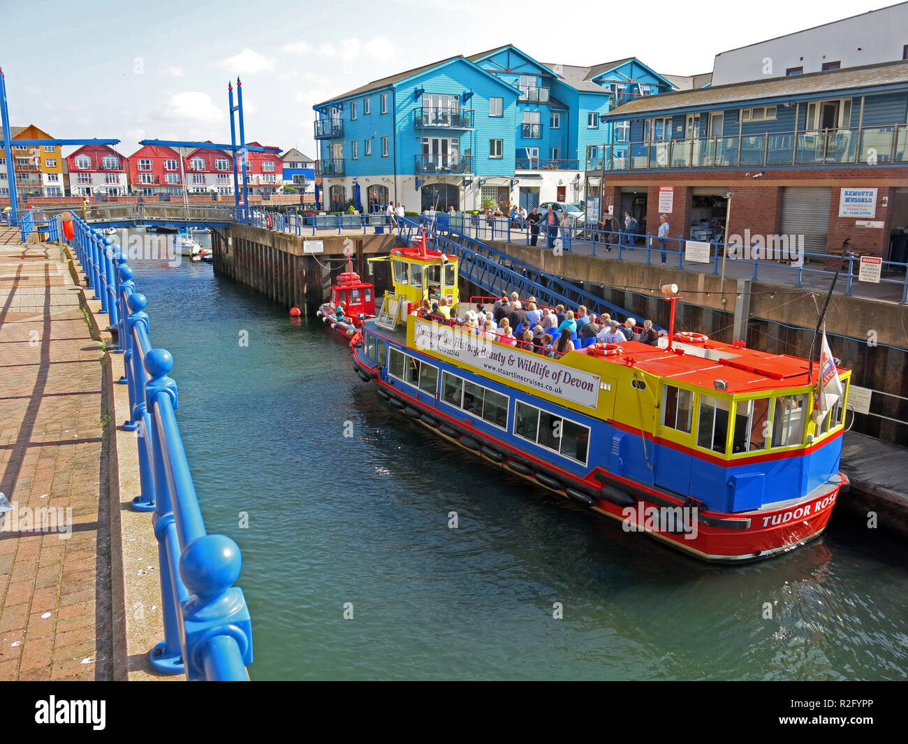 A colourful pleasure boat in the entrance to the old dock in Exmouth ...