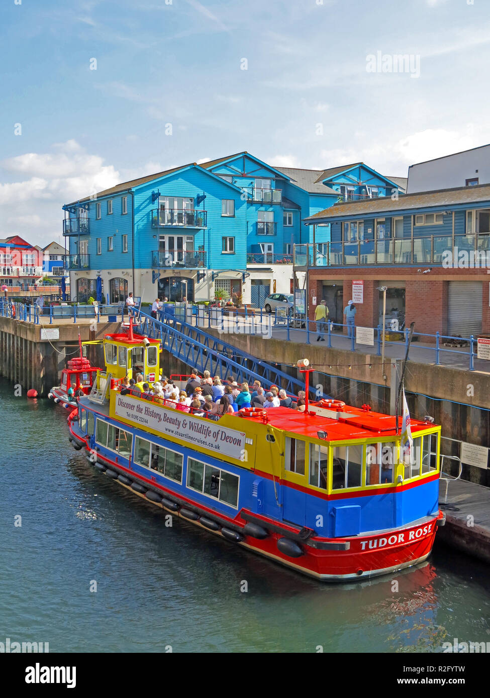 A colourful pleasure boat in the entrance to the old dock in Exmouth ...