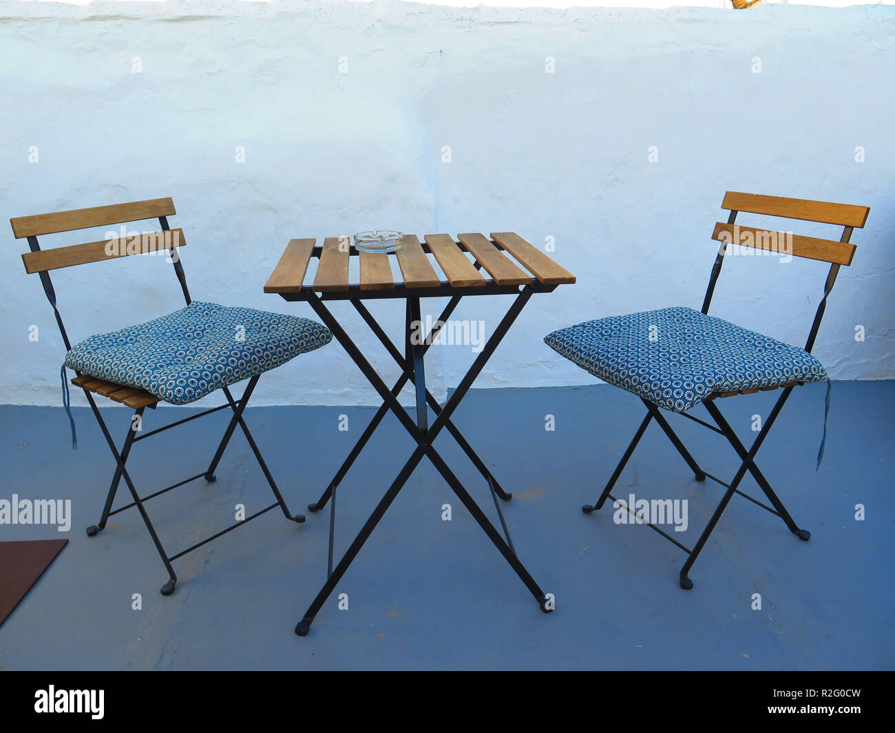 Two spindly chairs with cushions and small square table in Andalusian ...