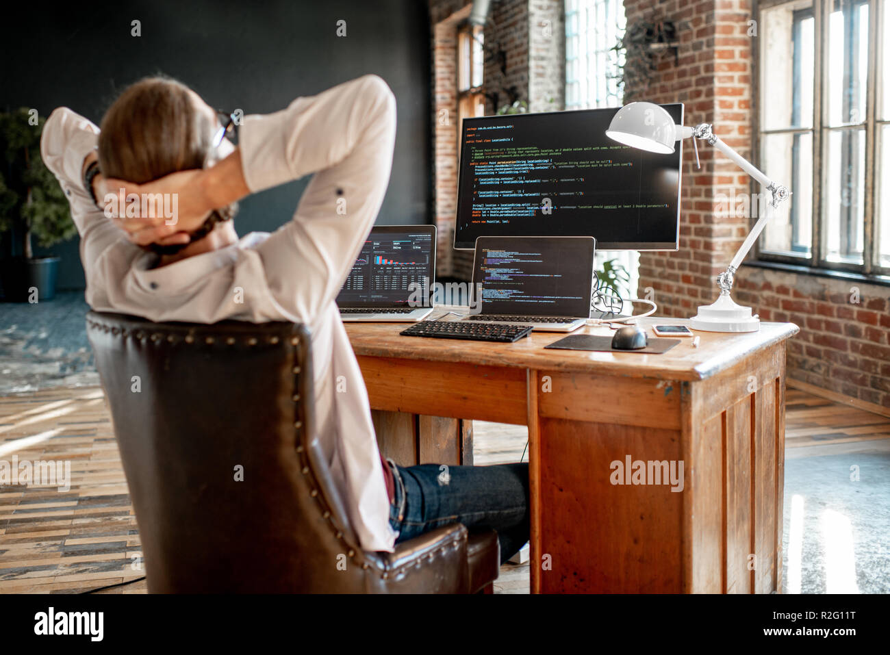 Young male programmer relaxing during the work with program code ...