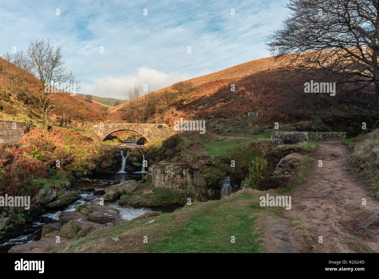 A waterfall and packhorse stone bridge at Three Shires Head in the Peak ...