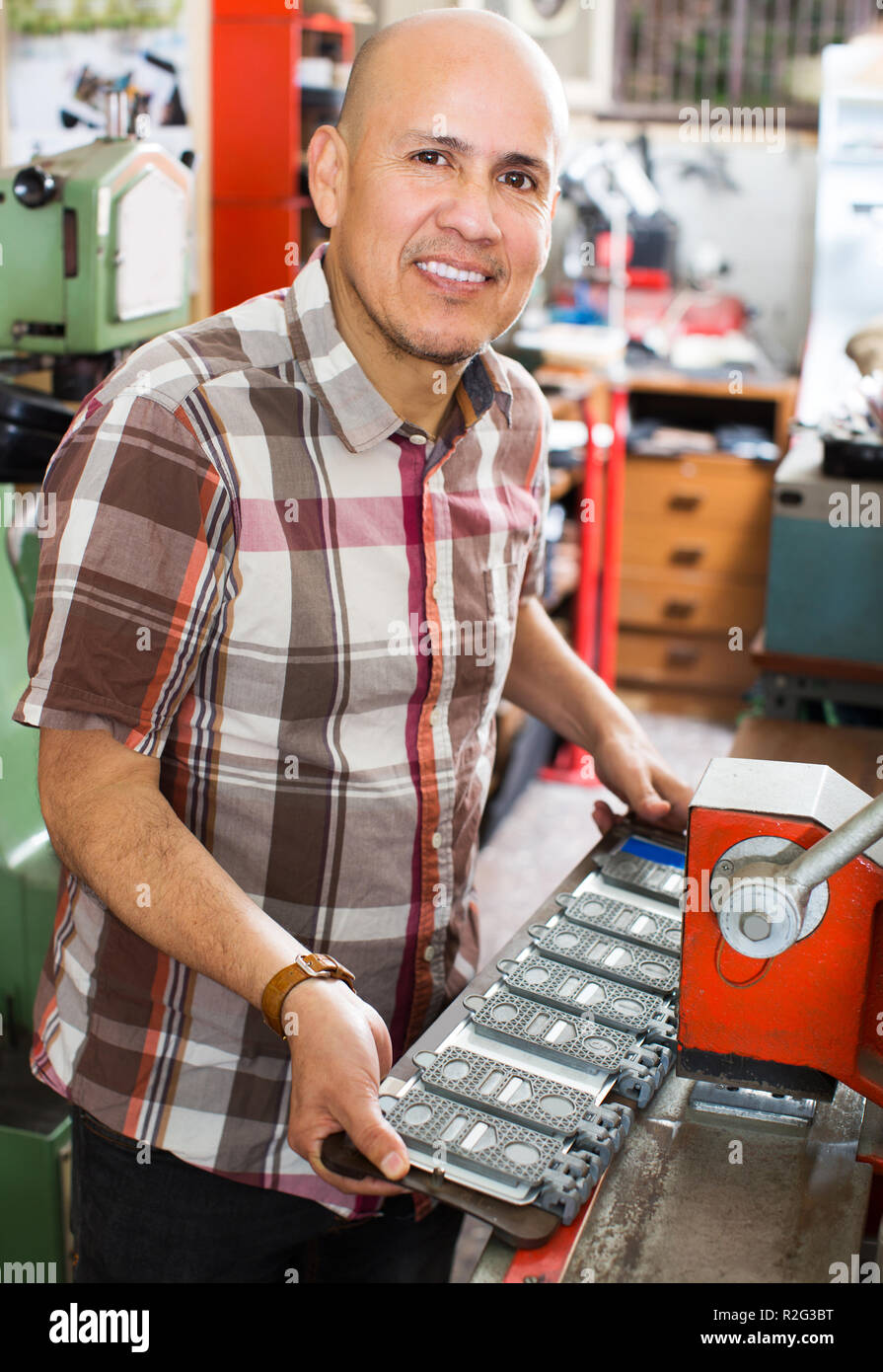 Elderly supplier making car number plate on printing system lathe Stock ...