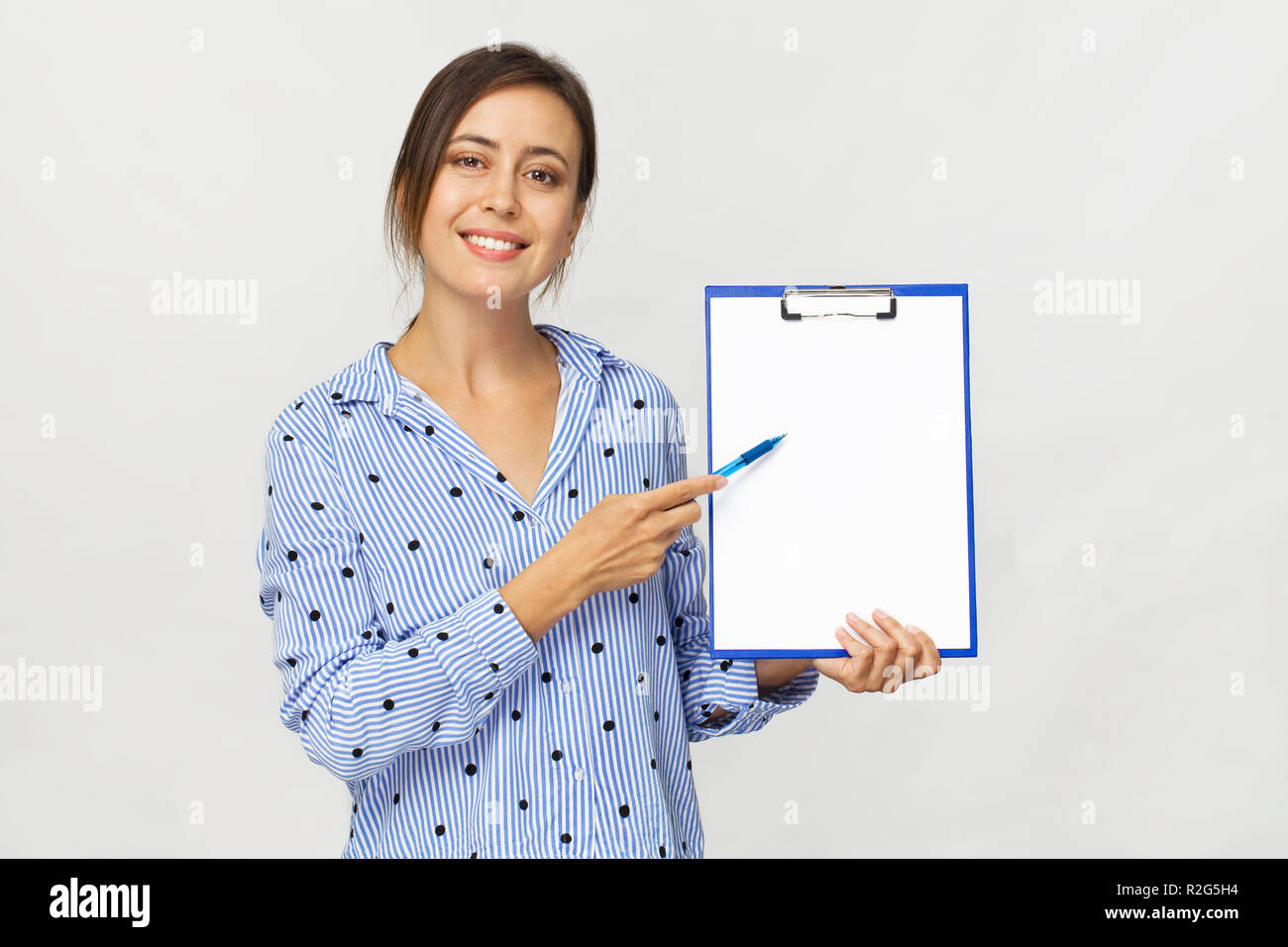 Beautiful woman point pen on clipboard, isolated on white background ...
