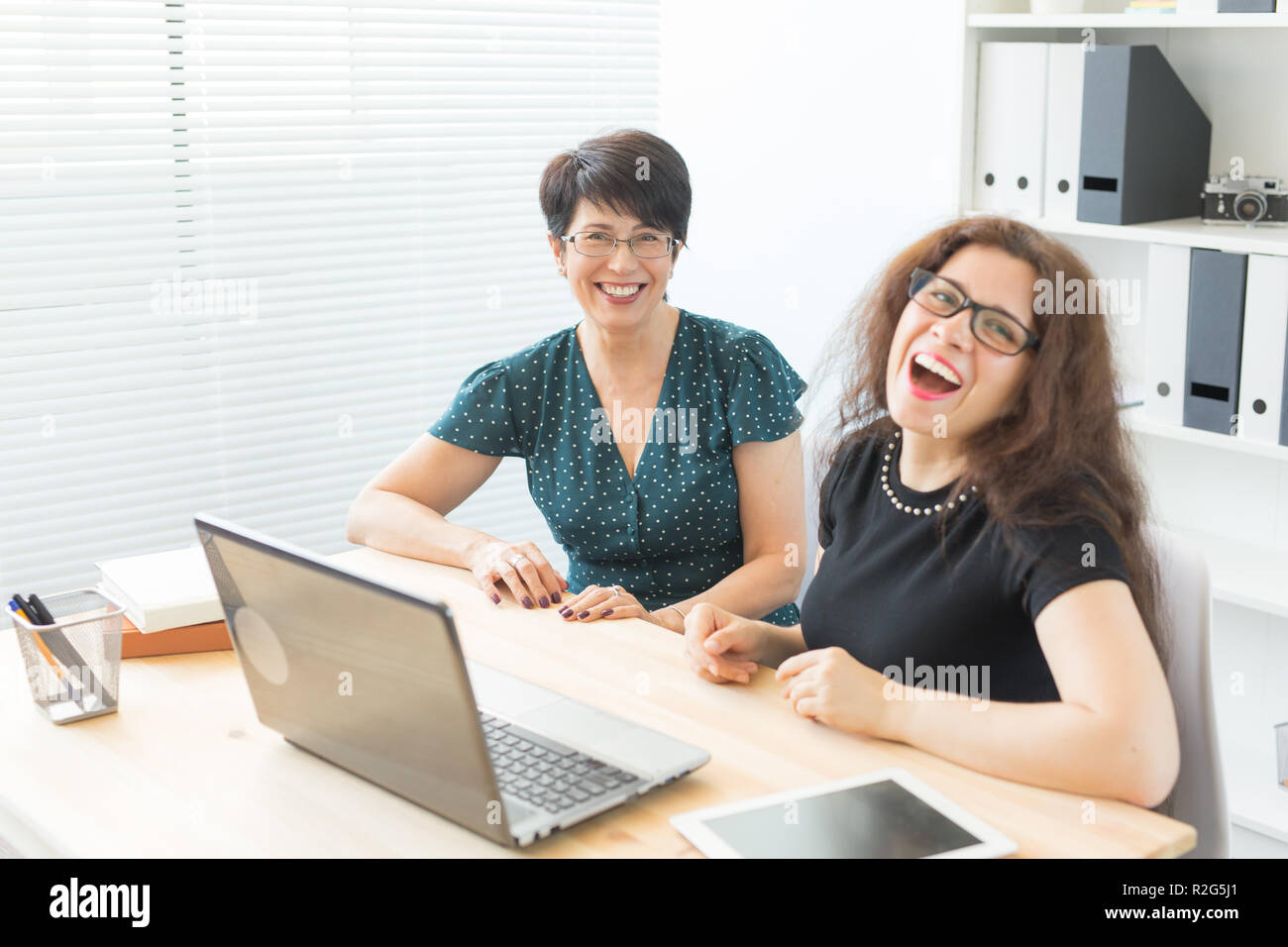Two happy business women working together in office interior Stock ...