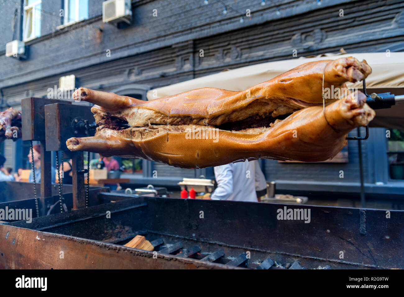 Grilled smoked whole pig on a skewer Stock Photo - Alamy